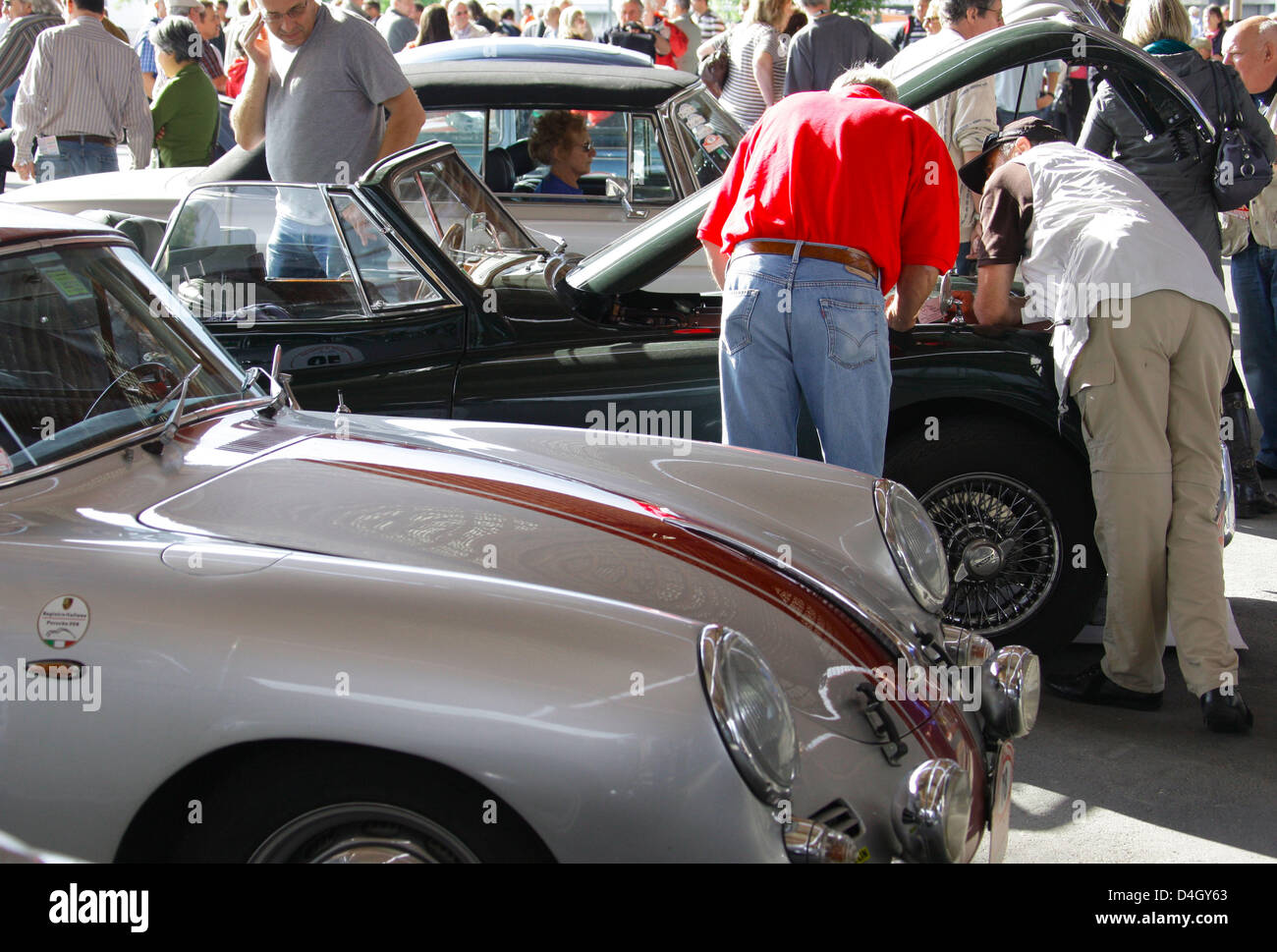 Spectators examine classic cars which had before crossed the finish ...