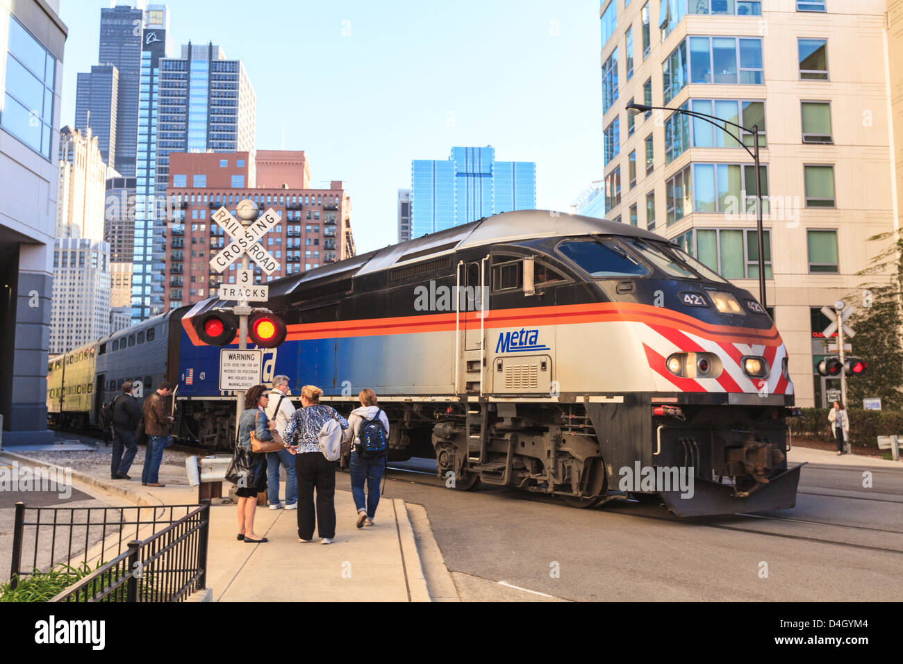 Metra Train passing pedestrians at an open railroad crossing, Downtown ...