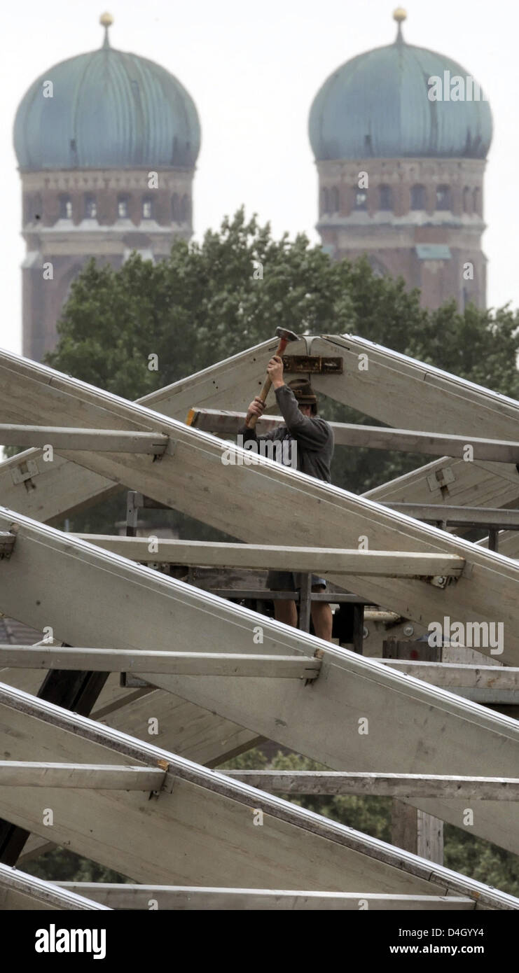 A worker sets up the roof truss of a beer tent on the compounds of the ...