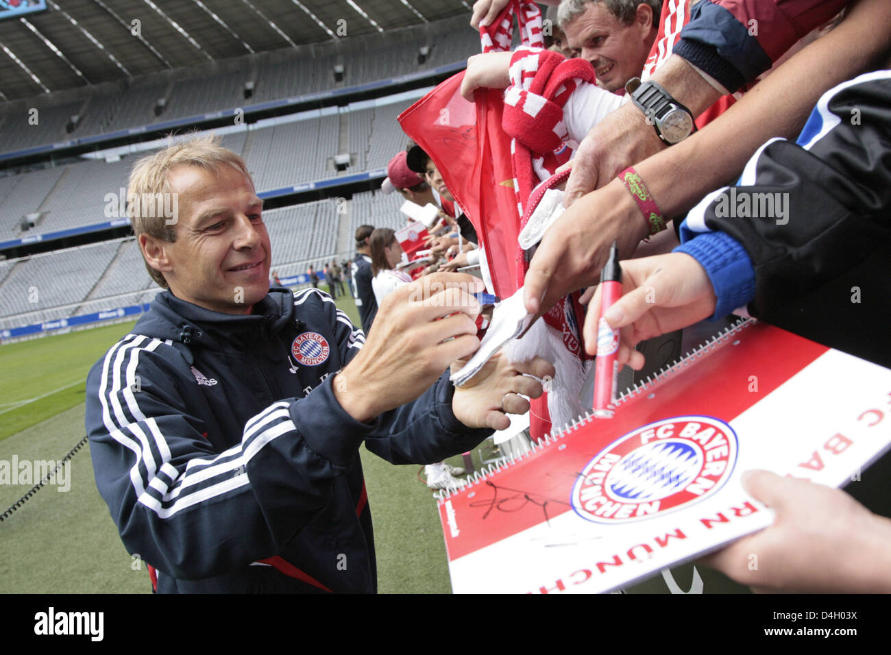 FC Bayern Munich head coach Juergen Klinsmann signs autographs after a ...