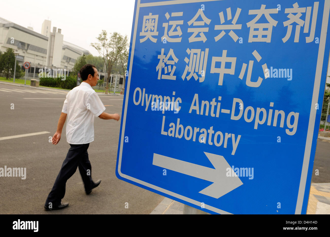A man walks past a blue sign reading 'olympic Anti-Doping Laboratory ...