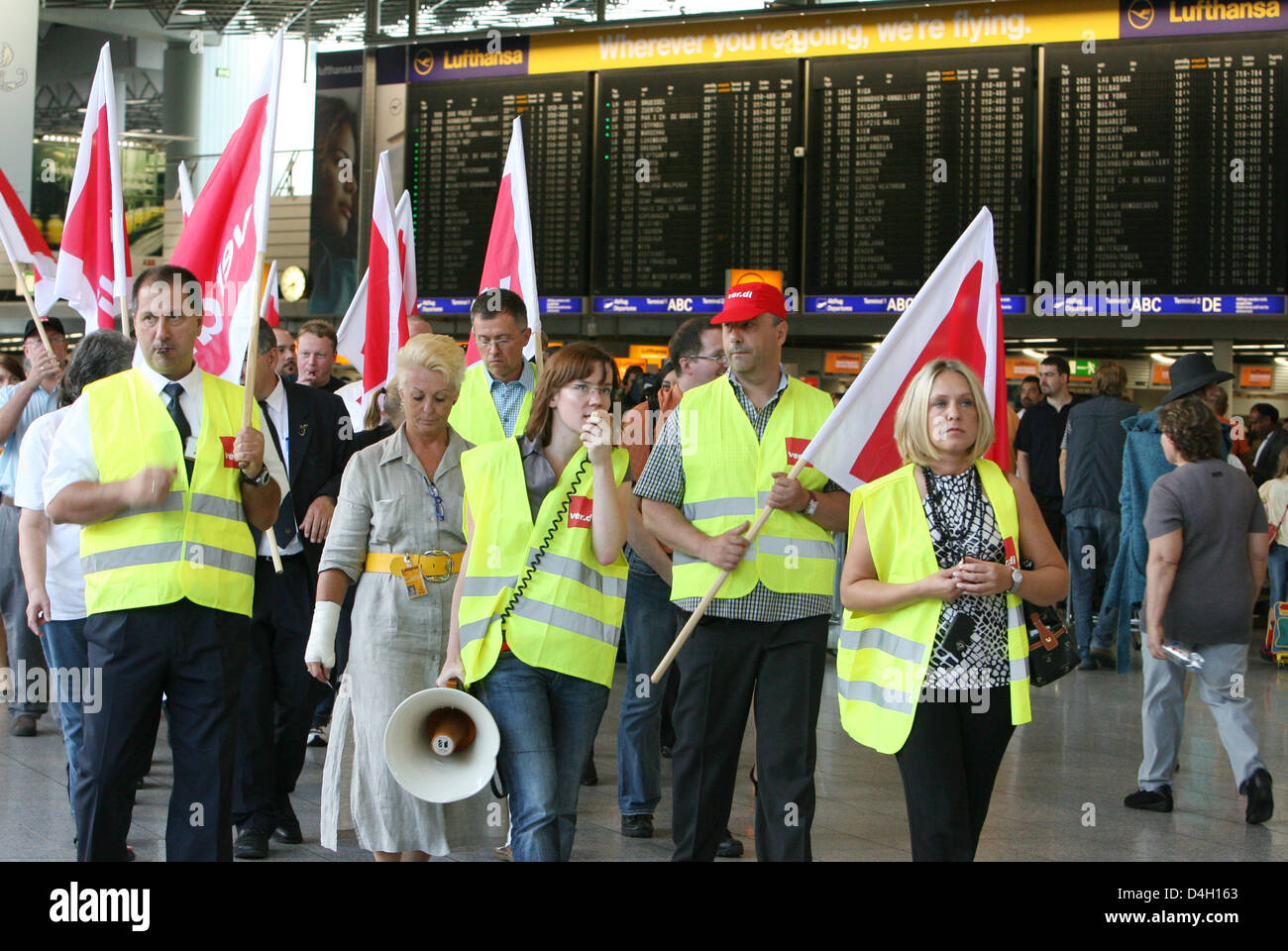 Union workers on strike pass by travellers with luggage at the Rhine ...