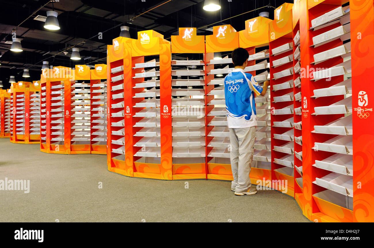 An Olympic helper puts information leaflets into shelves, sorted ...