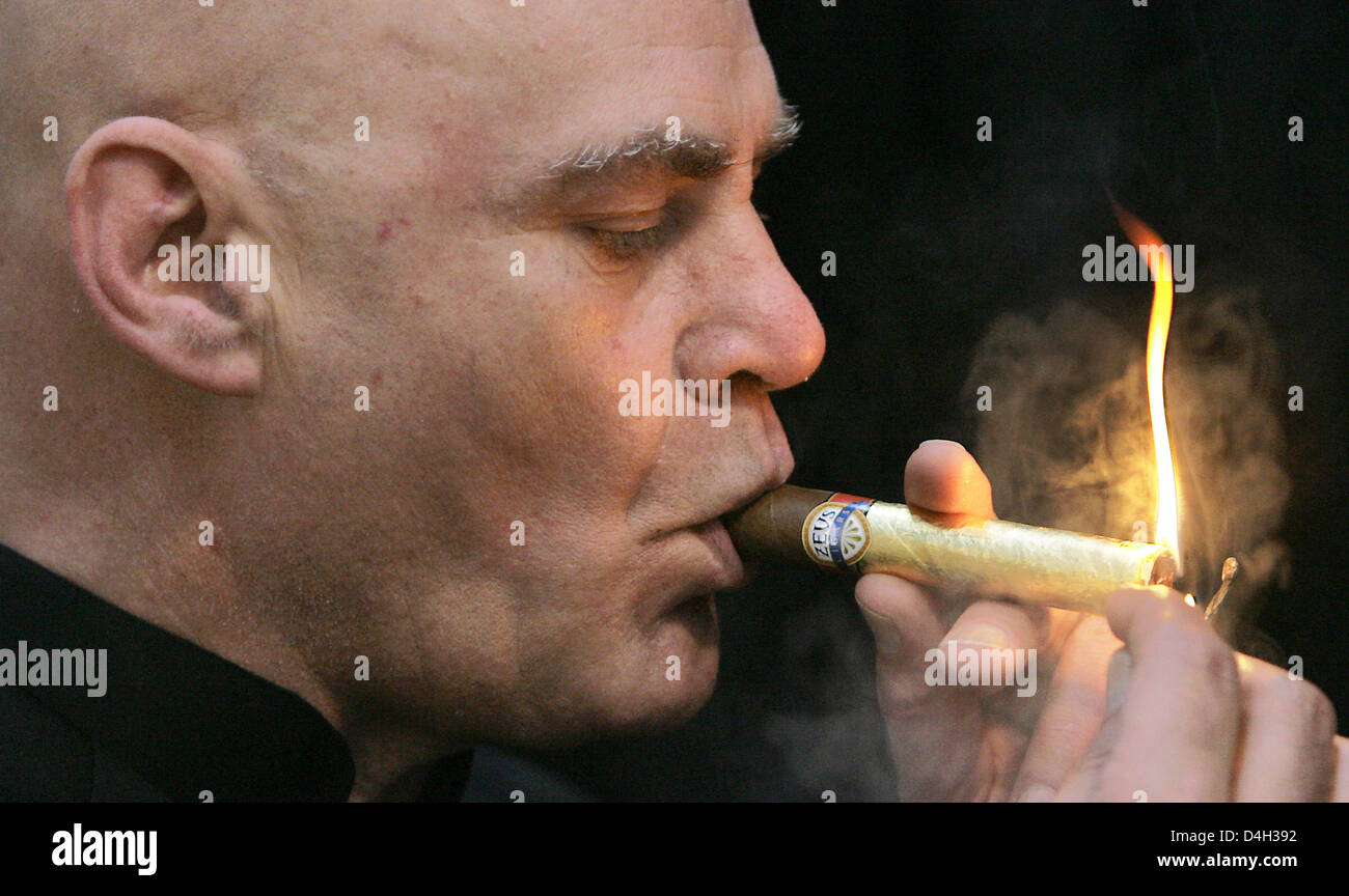 Peter Mai of 'Cigars Company' lights a cigar processed with pure gold ...