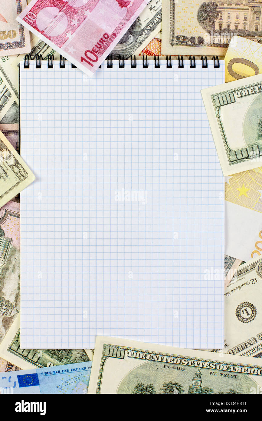 Opened spiral notepad (notebook) sheet in a cage on money background ...