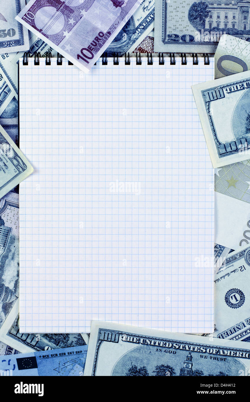 Opened spiral notepad (notebook) sheet in a cage on money background ...