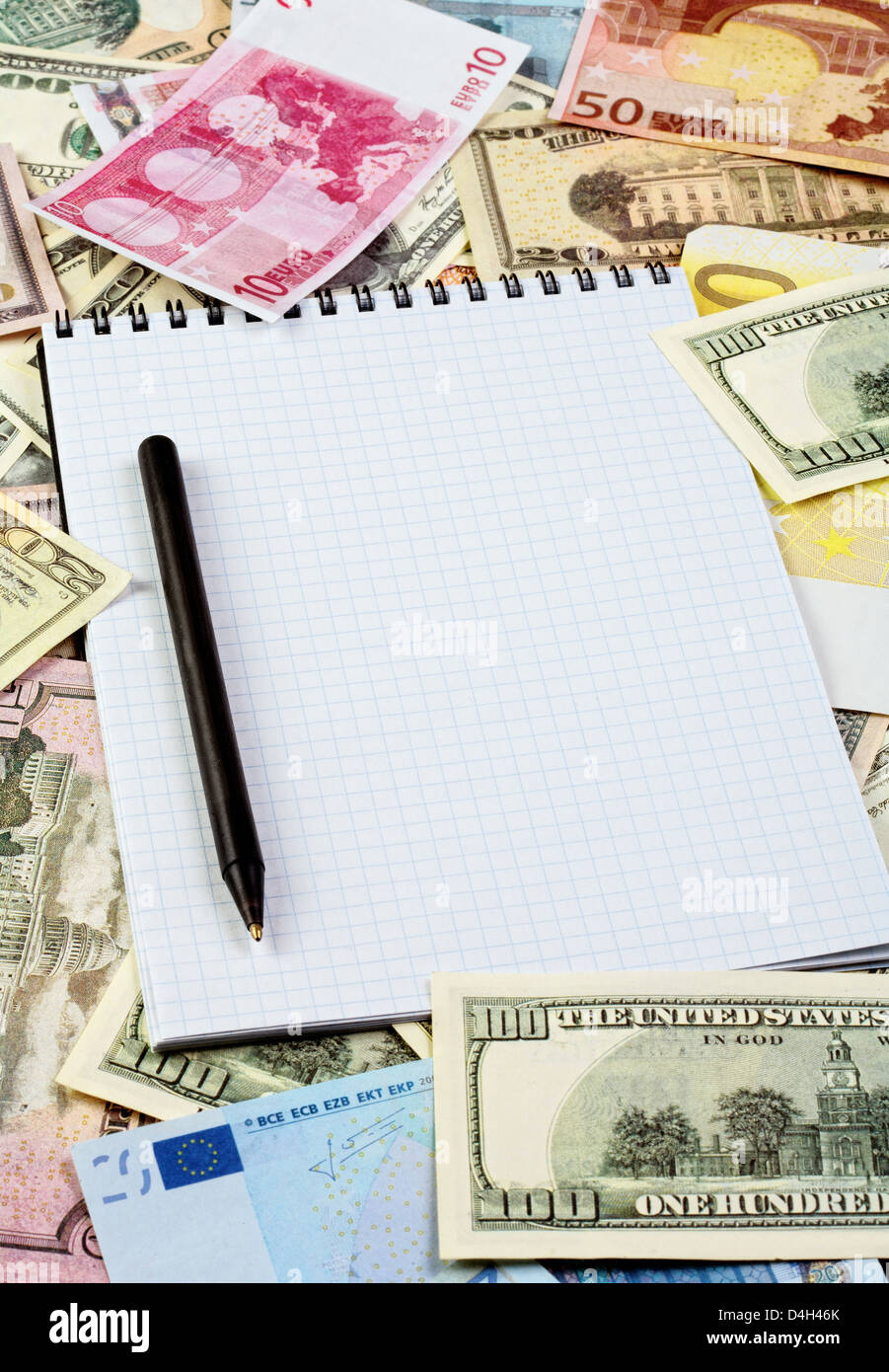 Opened spiral notepad (notebook) sheet in a cage on money background ...