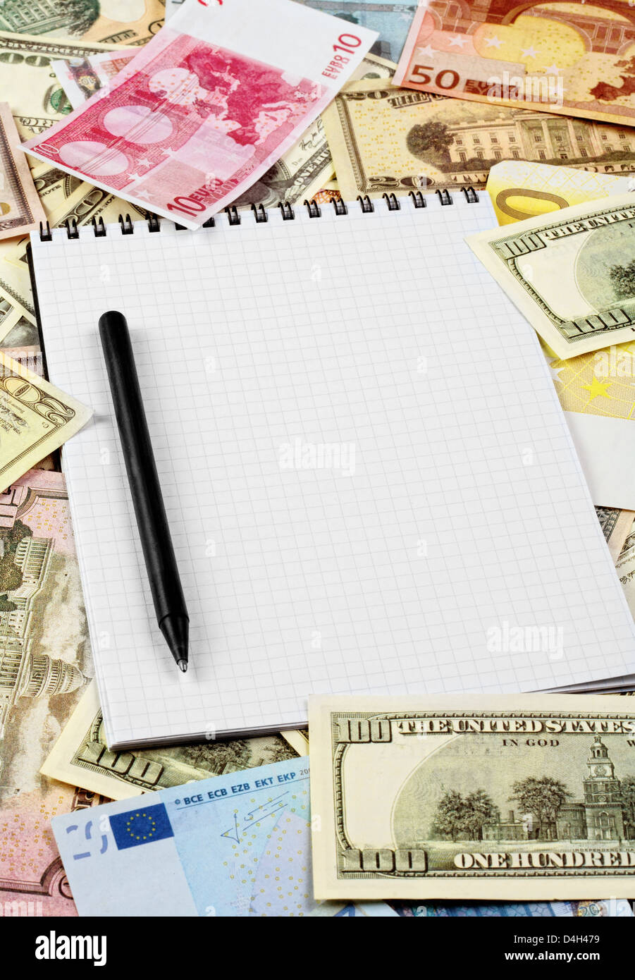 Opened spiral notepad (notebook) sheet in a cage on money background ...