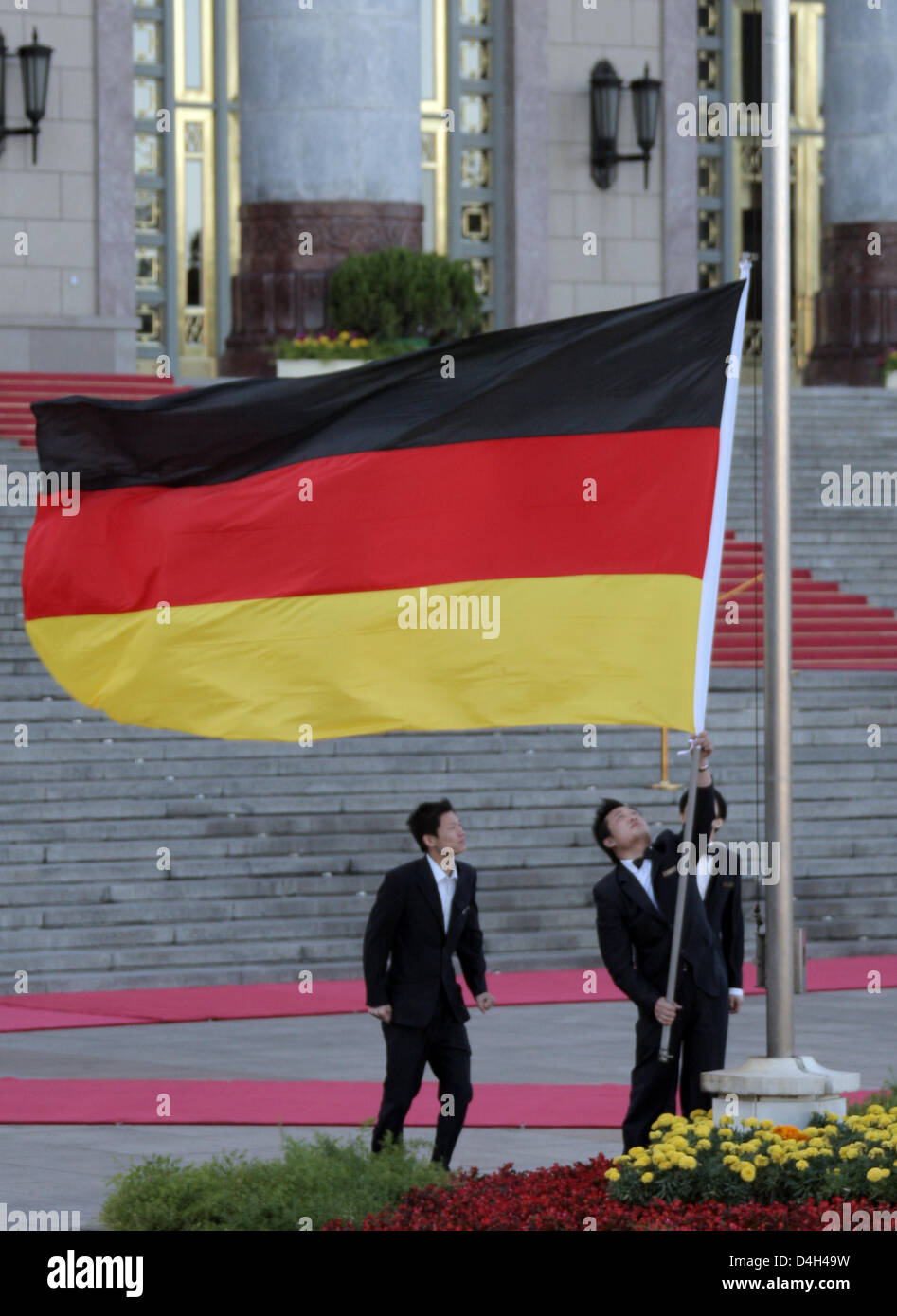 Assistants of the Chinese Prime Minister run up a German flag outside ...