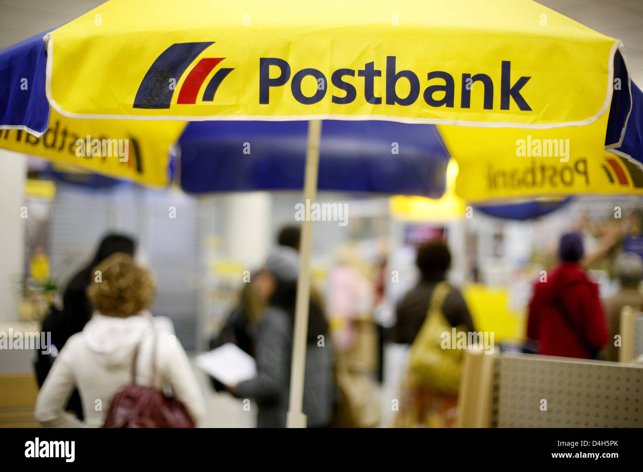 A sunshade with the logo of Deutsche Postbank stands in a branch of ...