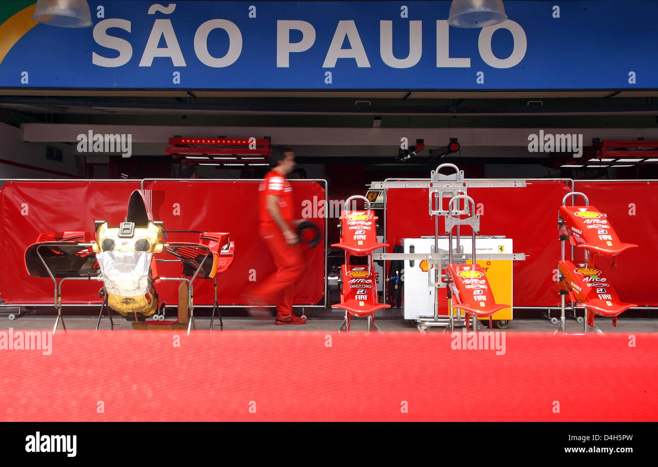 A mechanic of Ferrari walks through the pit lane as the Formula One ...