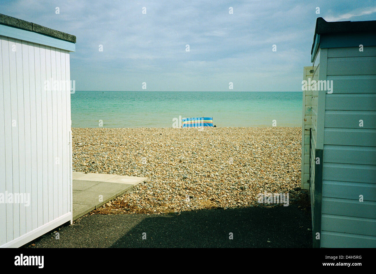 coloured windbreak on beach between beach huts, sussex, UK Stock Photo ...