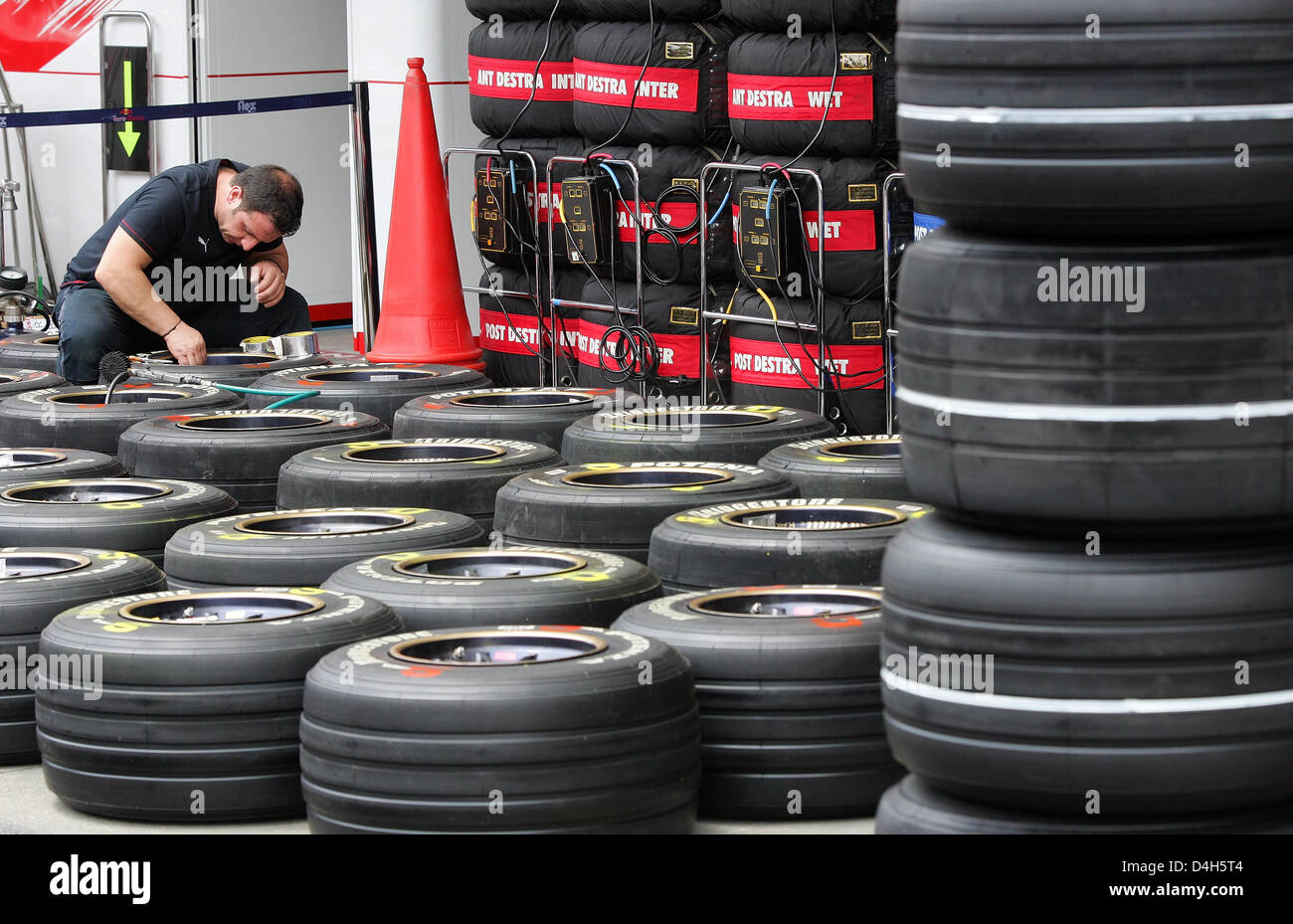 A mechanic prepares tires in the pit lane as the Formula One teams ...