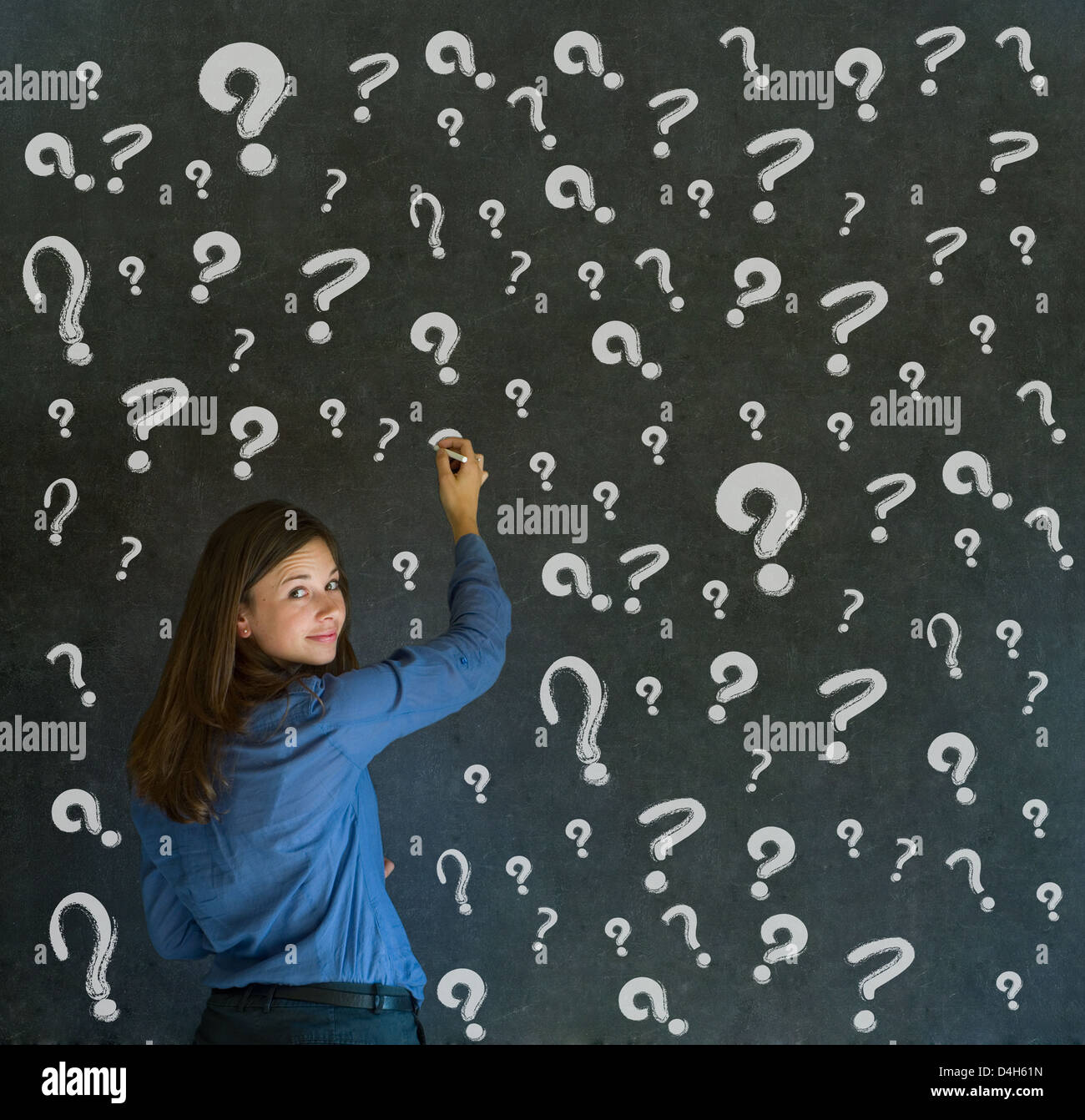 Thinking business woman with chalk questions marks on blackboard ...