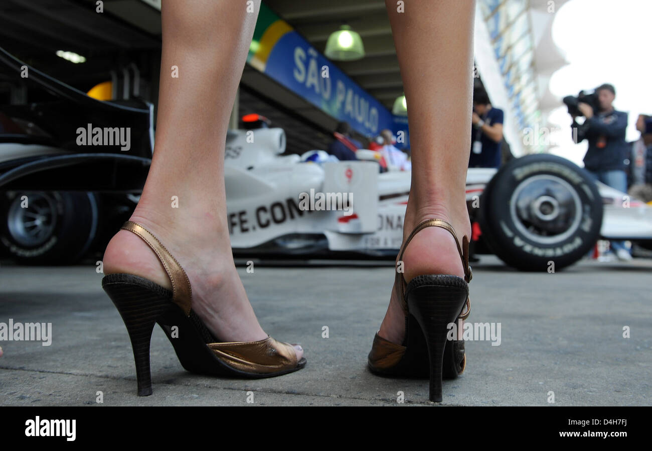 A girl on heels stands in front of the Red Bull garage during the third ...