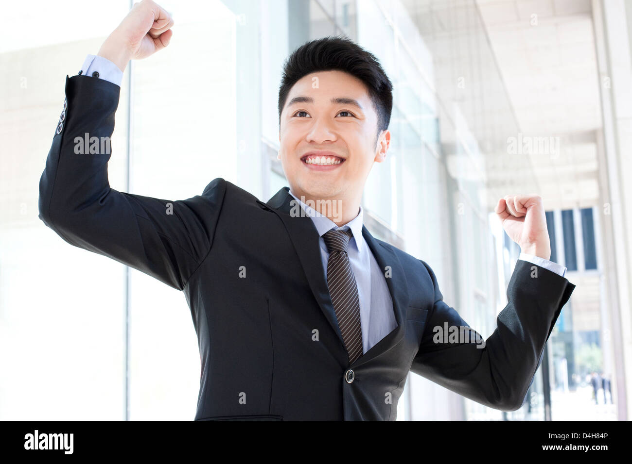 Cheerful businessman punching the air in CBD Stock Photo - Alamy