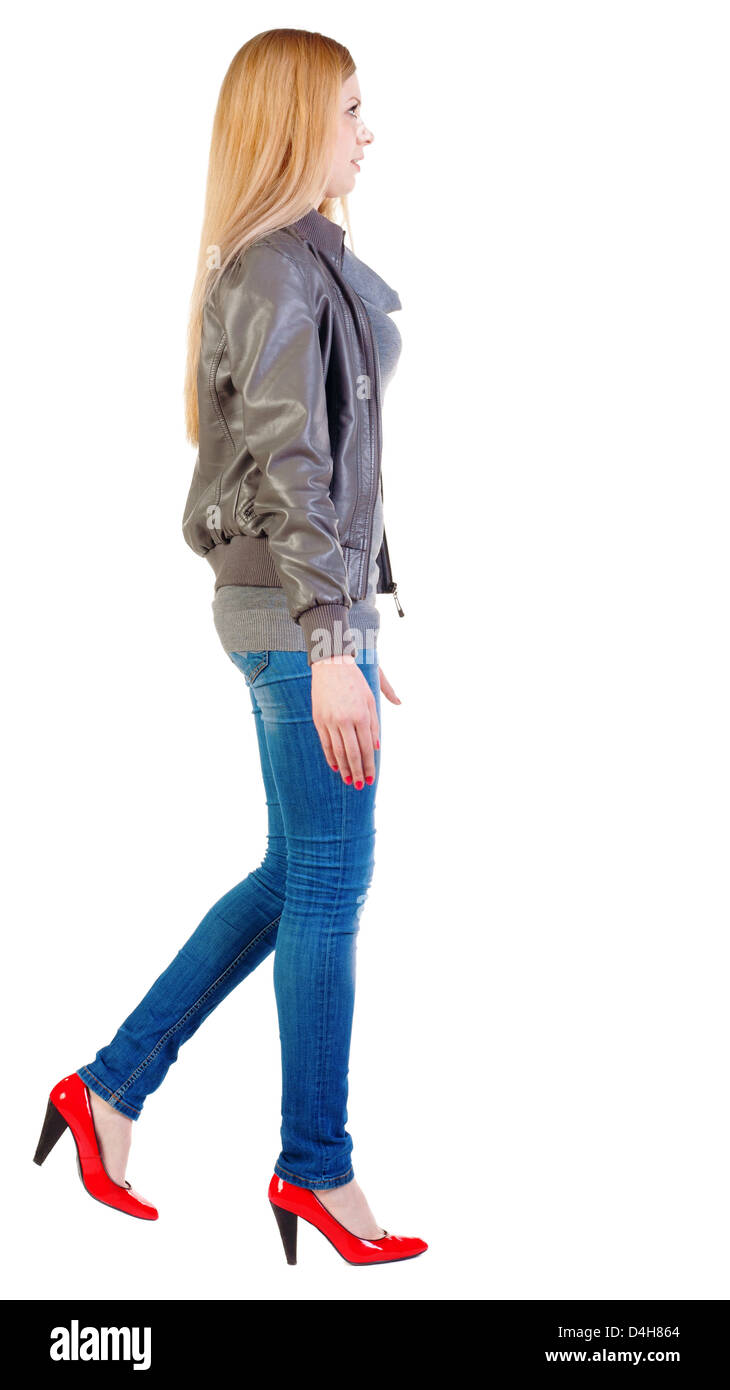 Beautiful girl in bright red heels is going to the right. Side view ...