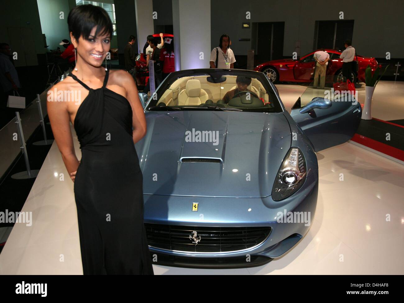 A hostess poses at the Ferrari booth of the Los Angeles Auto Show in ...