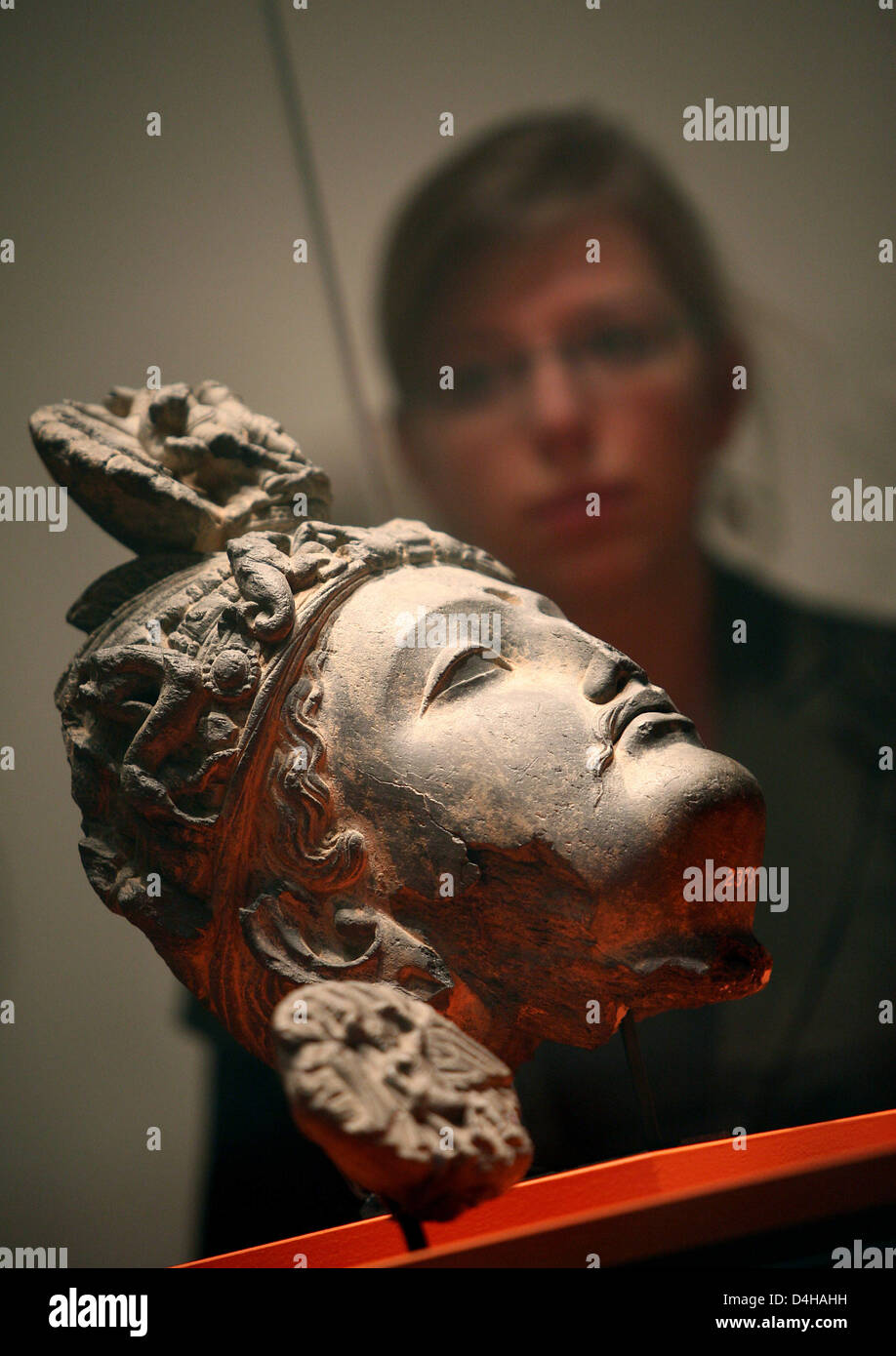 A woman looks at a slate Bodhisattva bust (dated 3rd century AD) on ...