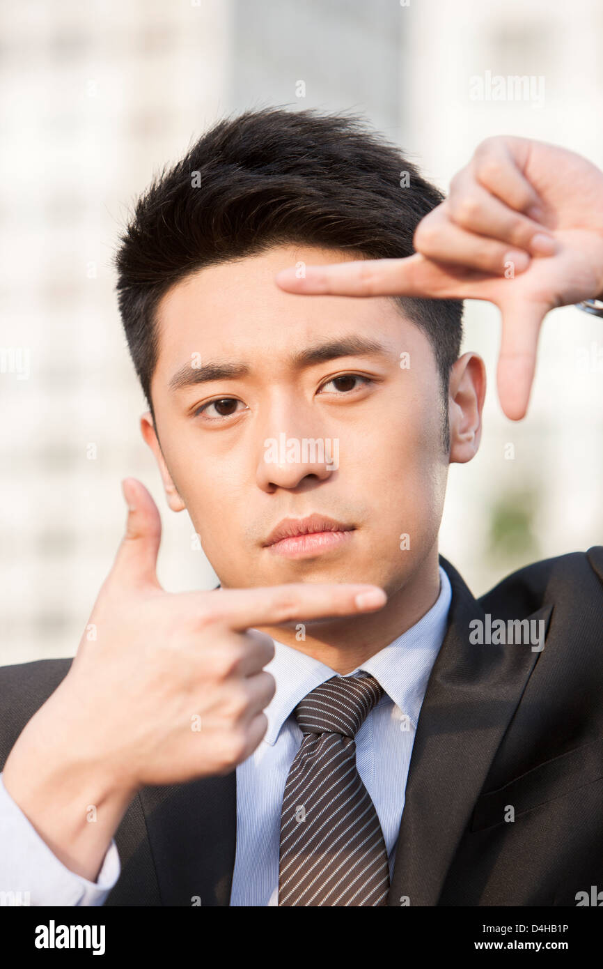 Serious young businessman doing finger frame in downtown district Stock ...