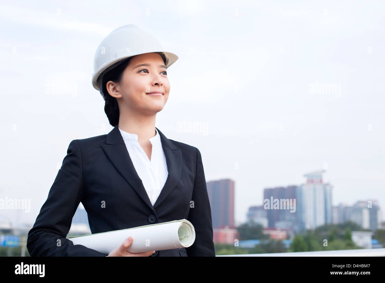 Young female architect with blueprint outdoors Stock Photo - Alamy