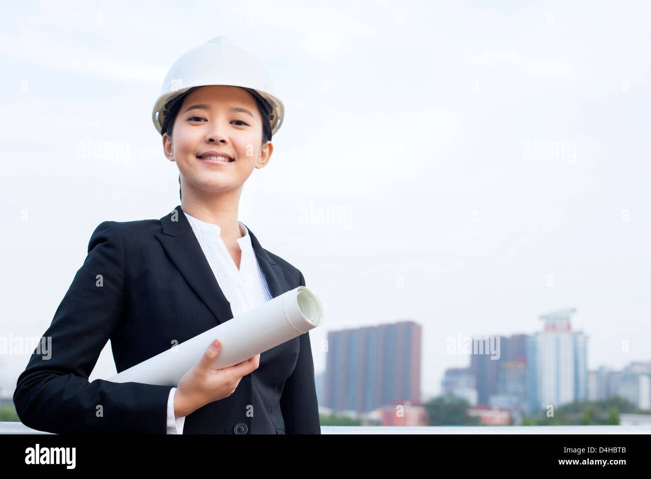 Young female architect with blueprint outdoors Stock Photo - Alamy