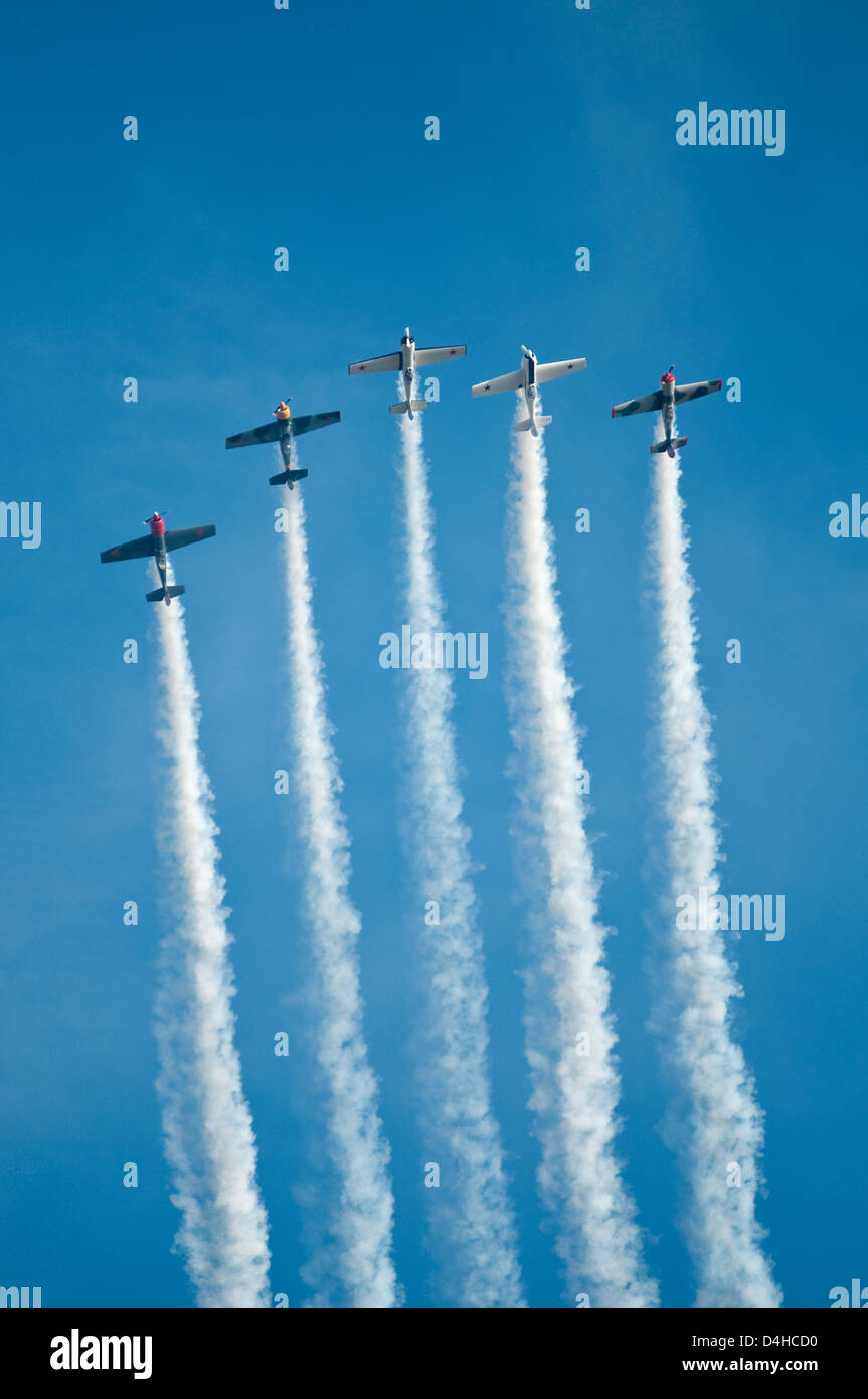 Portrait image of five aircraft flying in formation leaving smoke ...