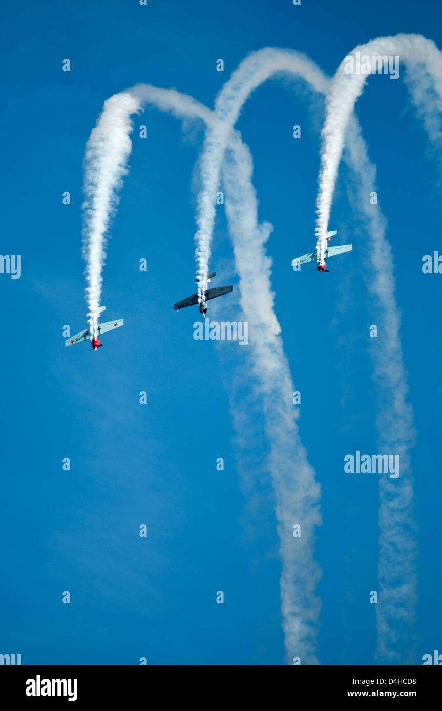 Portrait image of three aircraft flying in formation leaving smoke ...