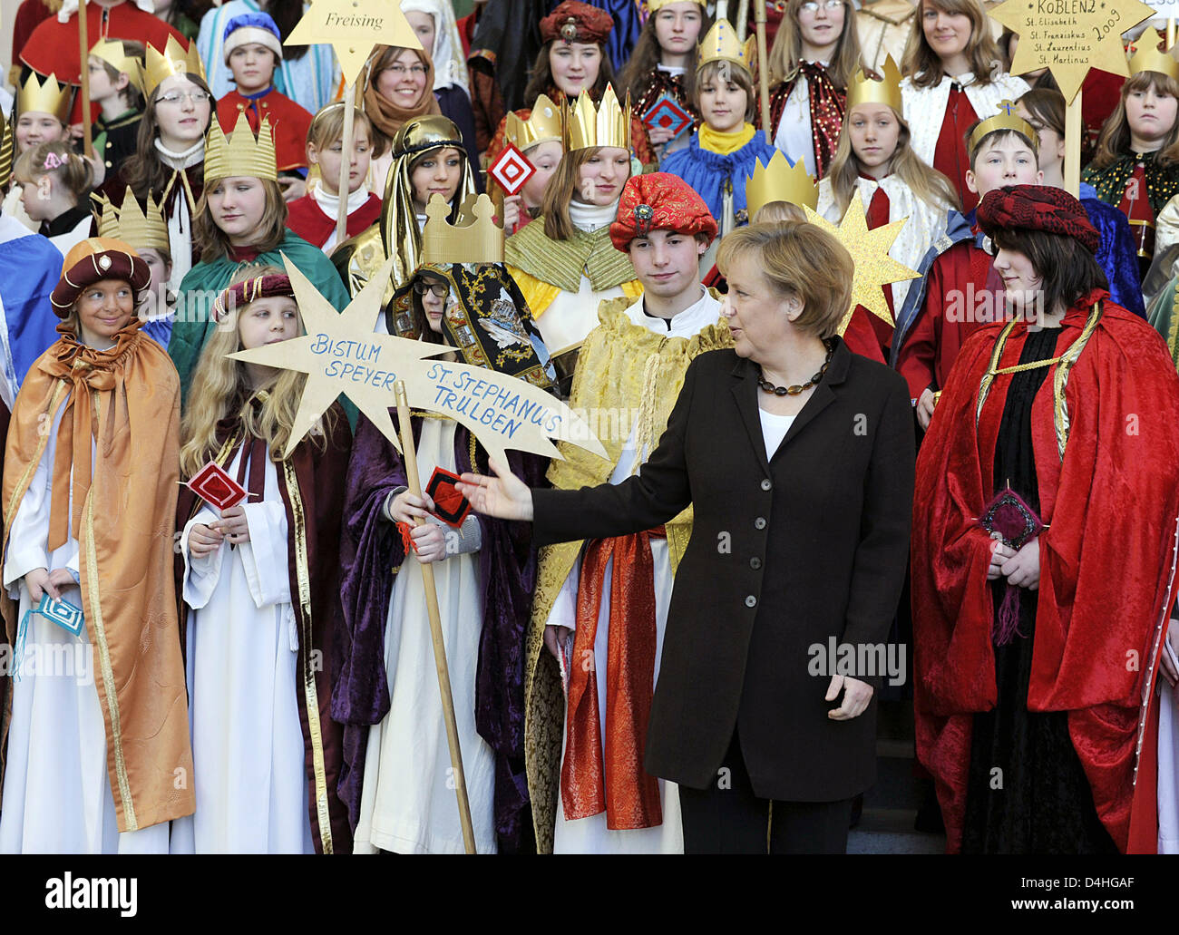 German Chancellor Angela Merkel (2-R) talks to young carollers from all ...