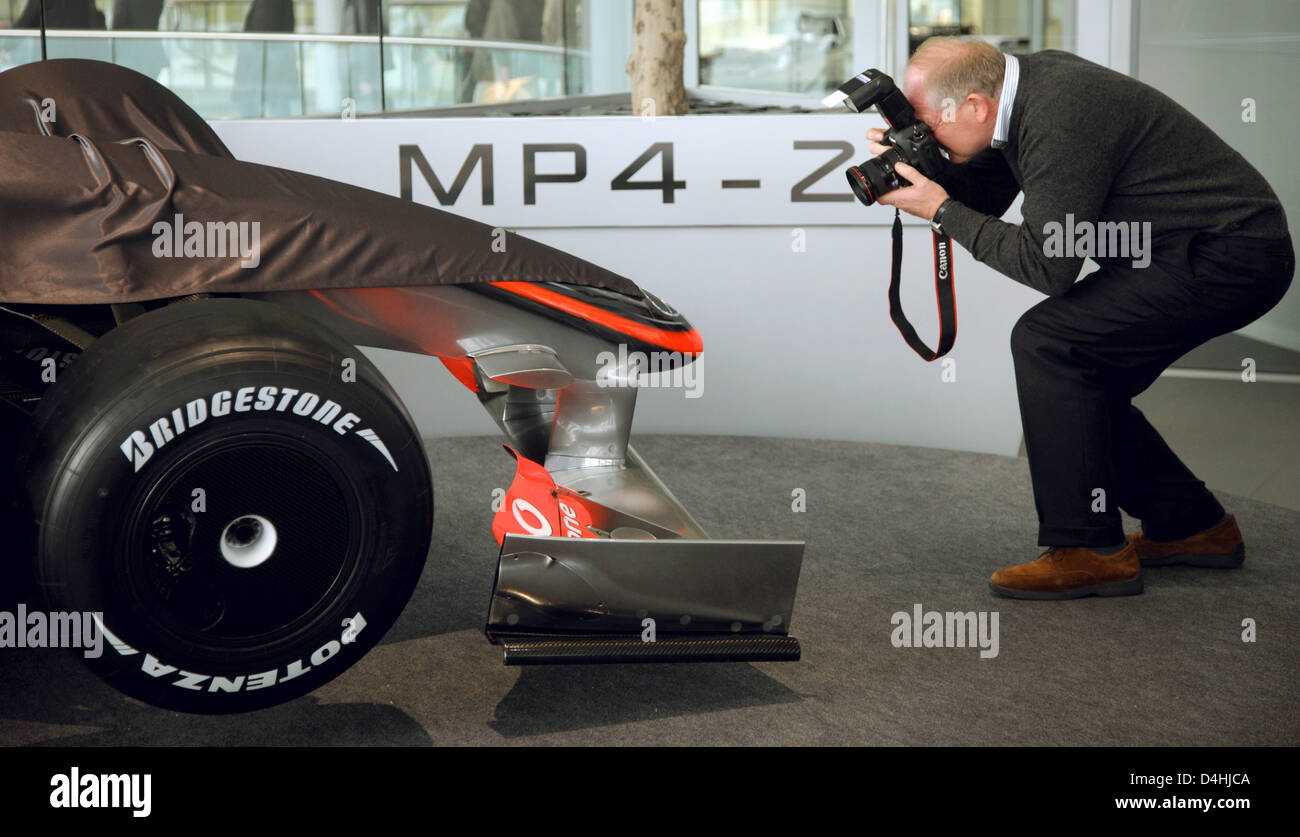 A photographer takes a picture of the front of the new racing car MP4 ...