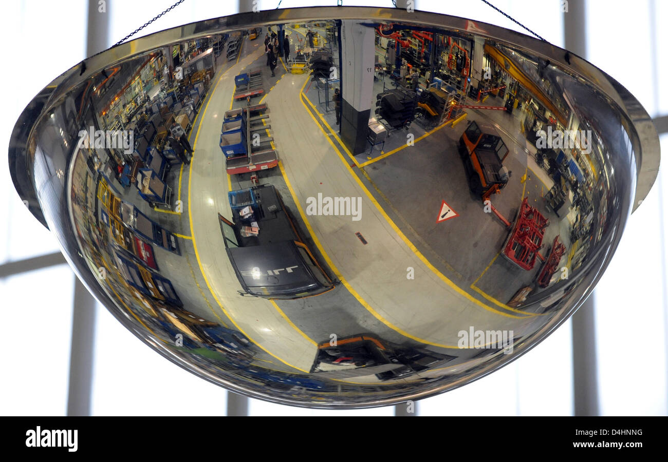 A mirror reflects employees employees of German engineering company MAN ...