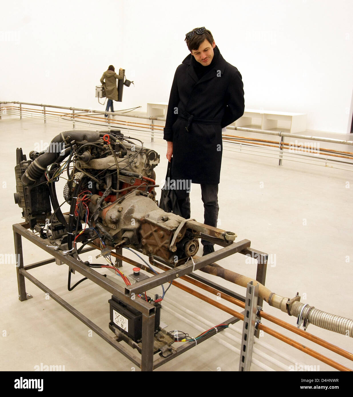 A visitor eyes the Volvo-engine of the mud brick installation ?Under ...