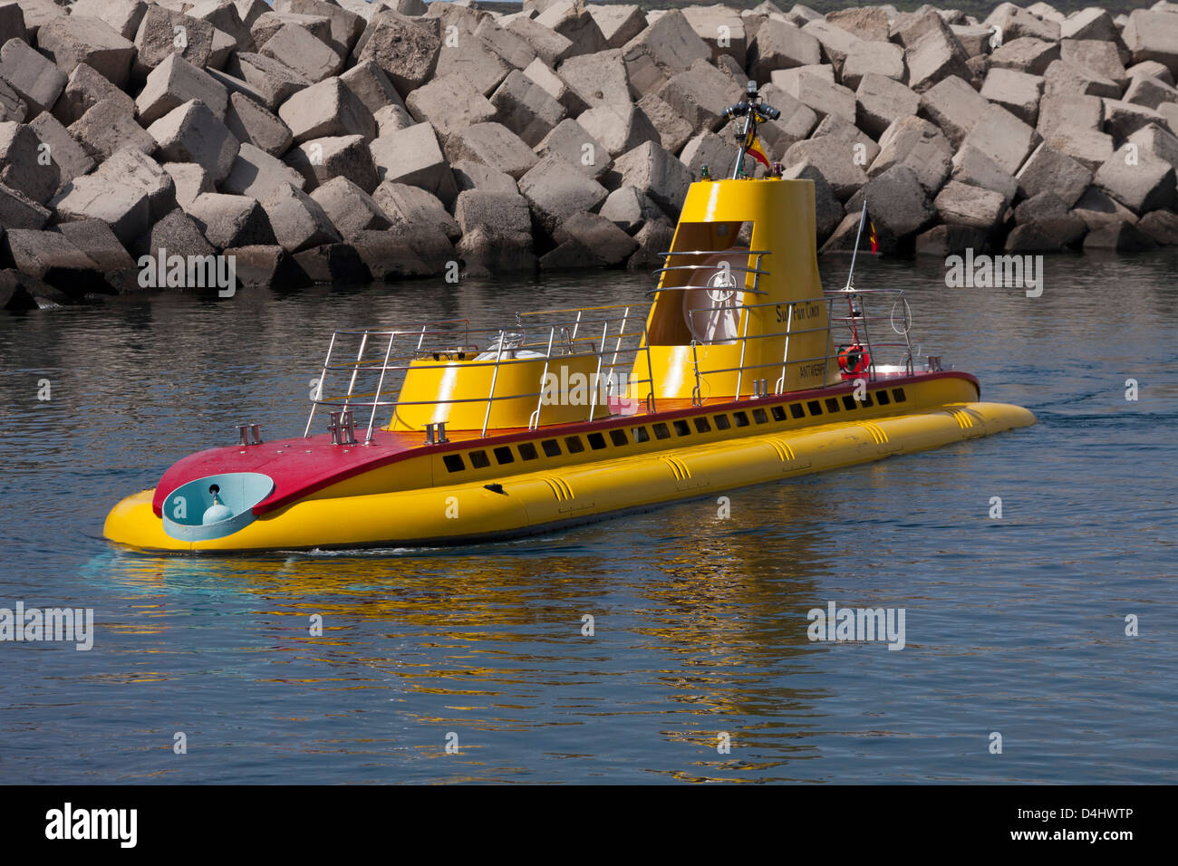 Yellow tourist submarine heading past a breakwater to the open sea from ...