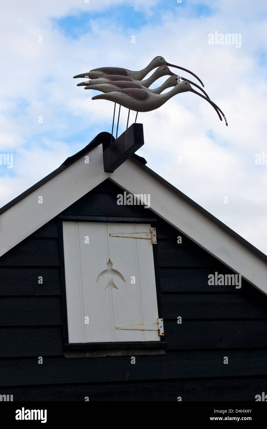 Wooden birds on top of a shed Stock Photo - Alamy