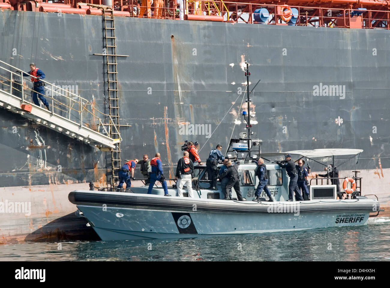 This image shows the Coast Guard engaging in joint boarding operations ...