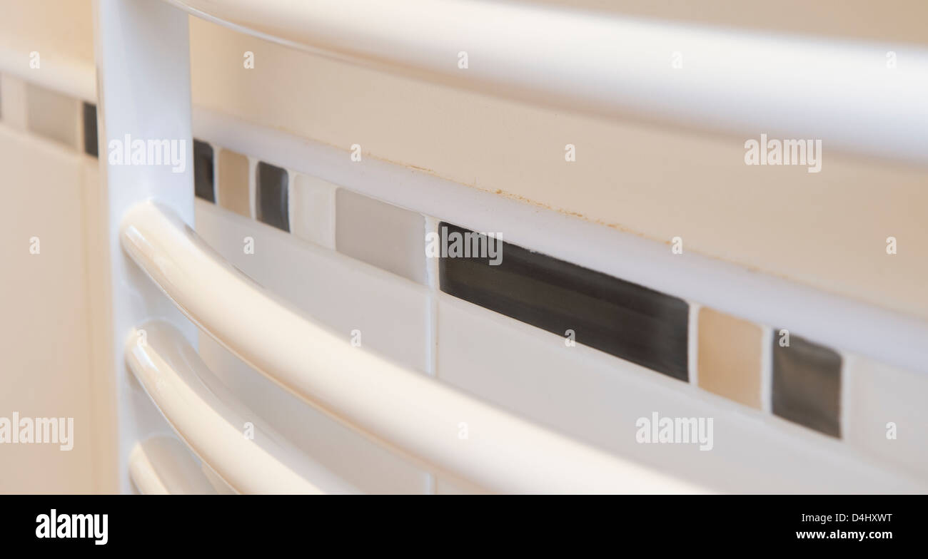 Close up of a wall mounted towel radiator and tiling in a newly ...