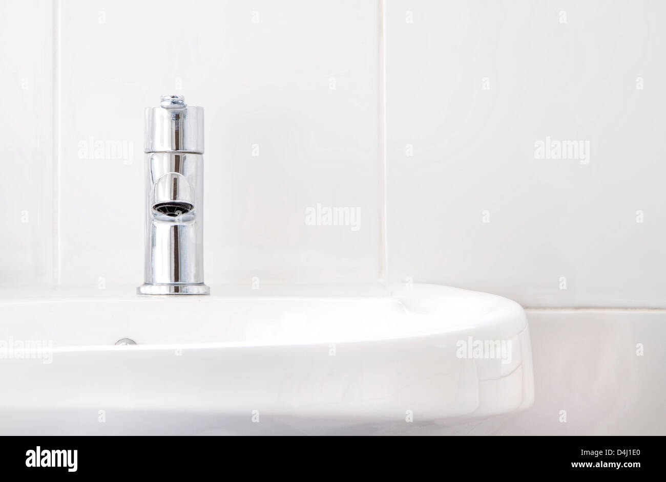 One tap on white bathroom basin with white tiles Stock Photo - Alamy