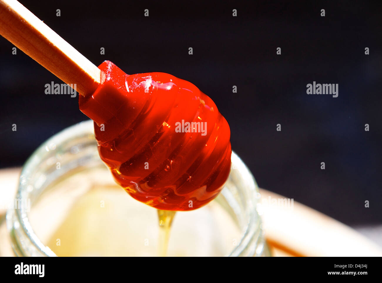 Honey on red drizzler Stock Photo - Alamy