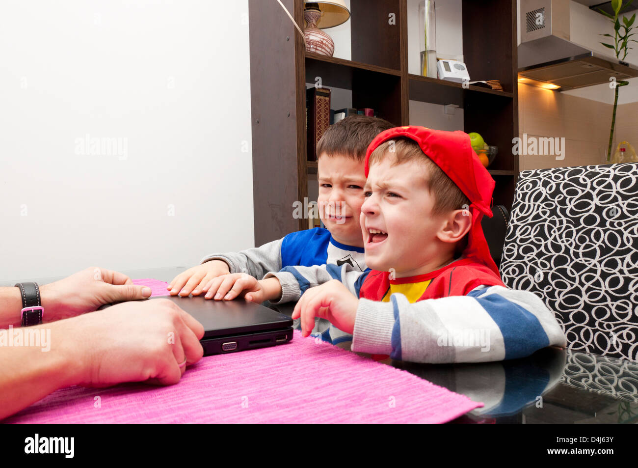 Father makes children sad and takes their laptop Stock Photo - Alamy