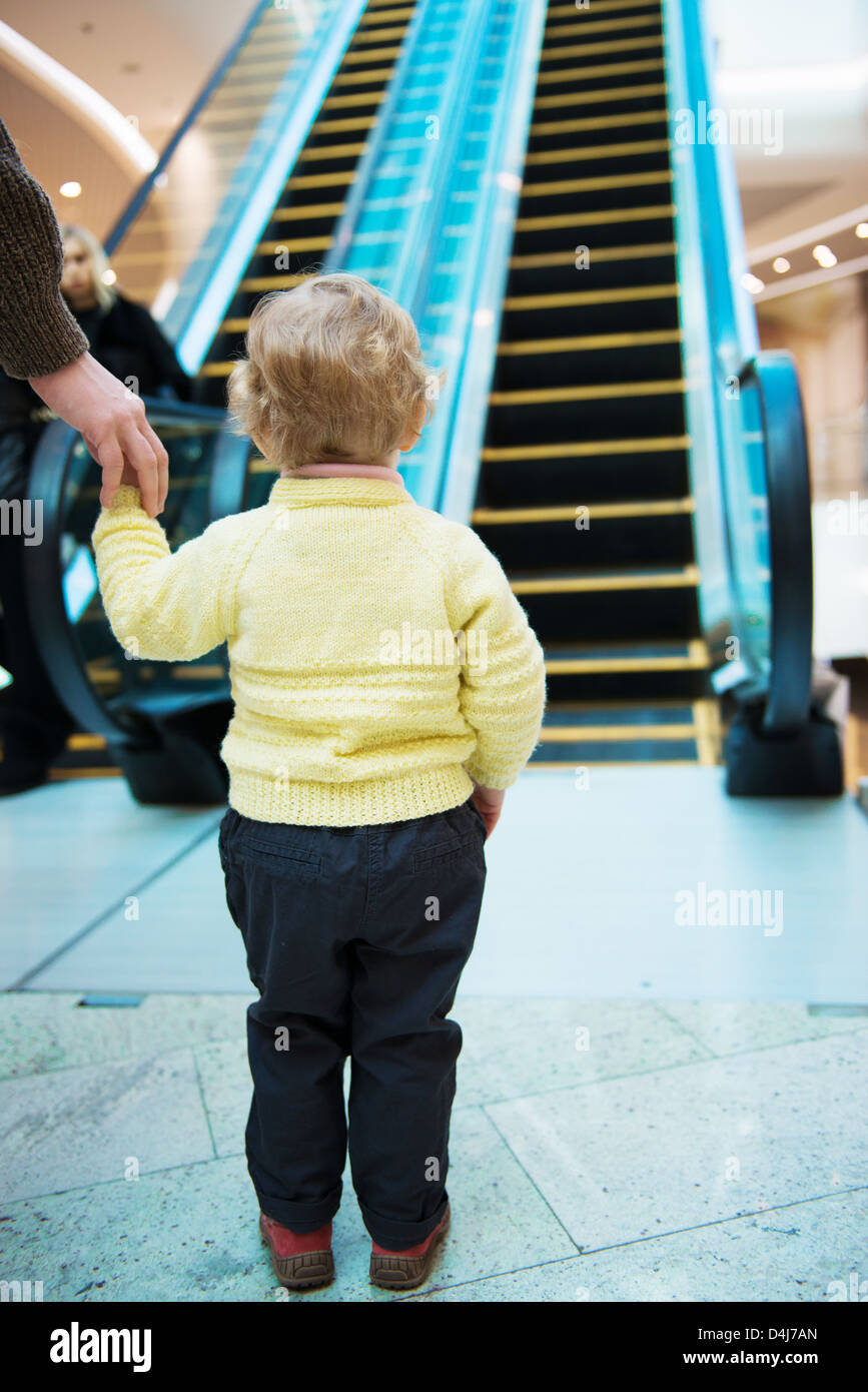Little girl with father standing in front of escalator Stock Photo - Alamy