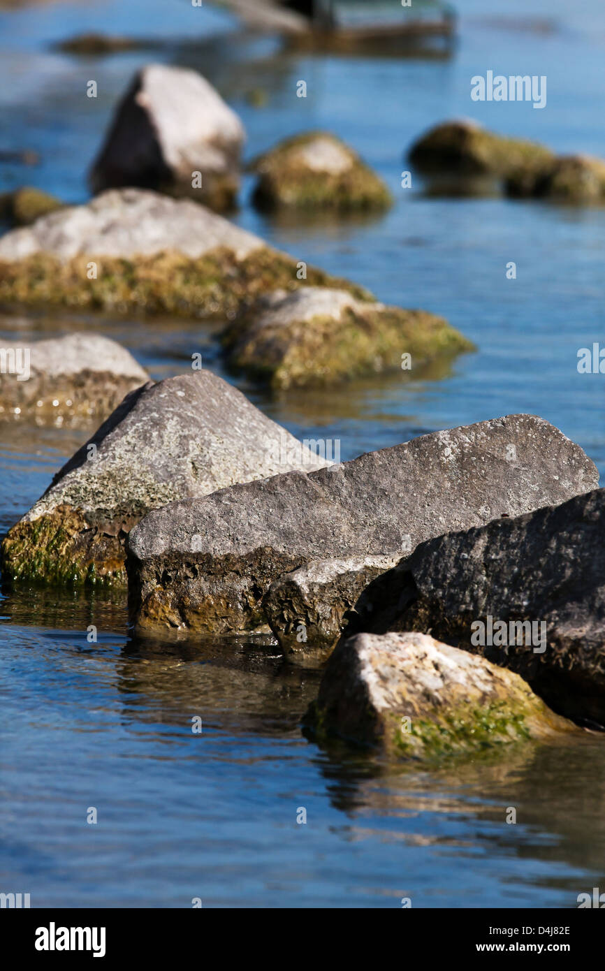 Beautiful waterfront mossy rocks in sunshine Stock Photo - Alamy