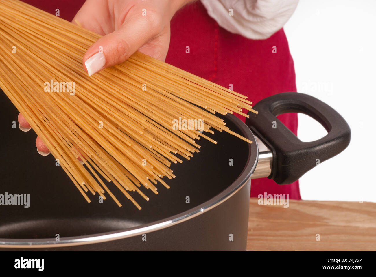 Spaghetti being held over a cooking pot Stock Photo - Alamy
