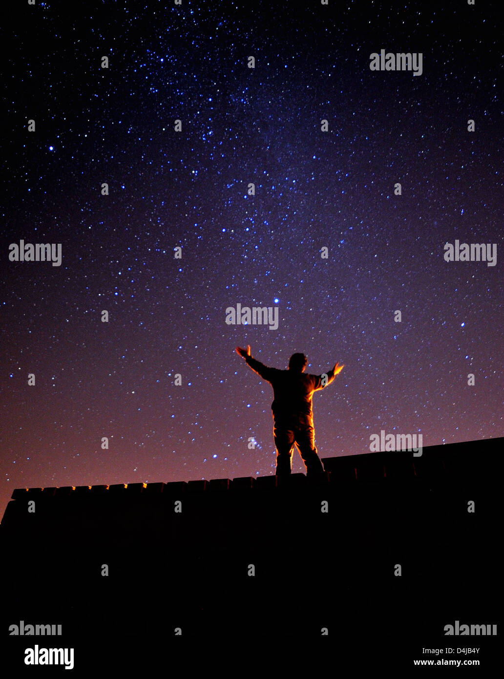 Lone man gazing upon stars during clear night Stock Photo - Alamy