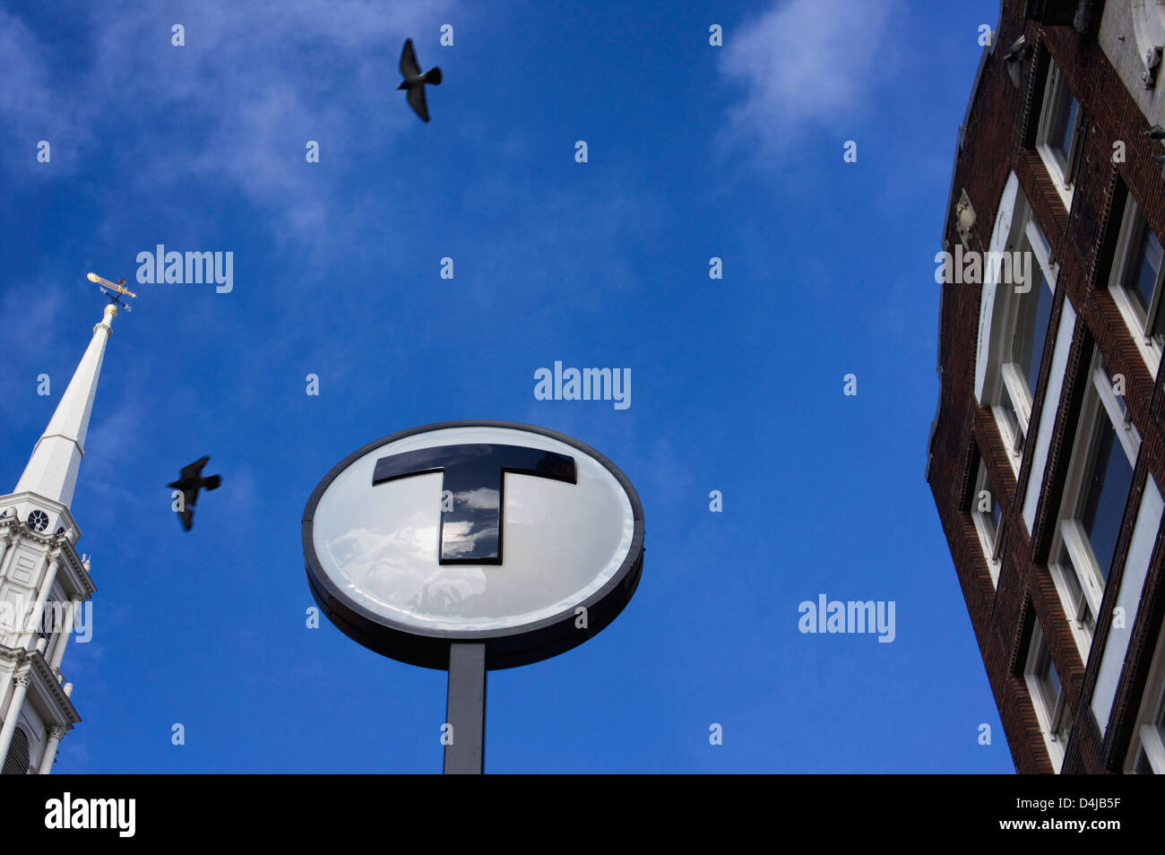 Park Street train station exit with T sign against sky with birds in ...