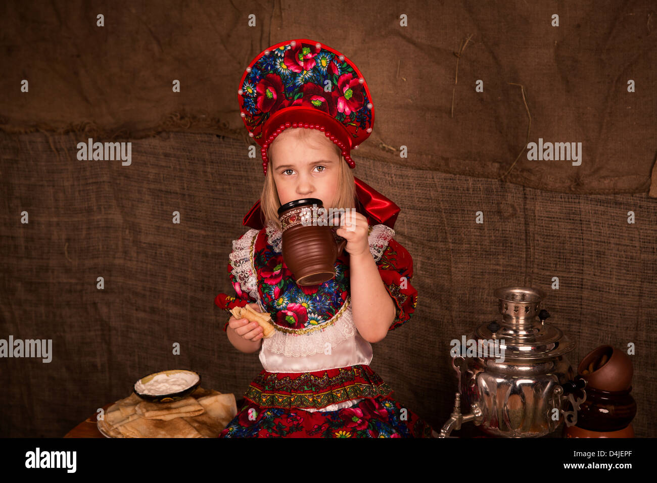 Beautiful russian girl drinking tea and eating pancakes Stock Photo - Alamy