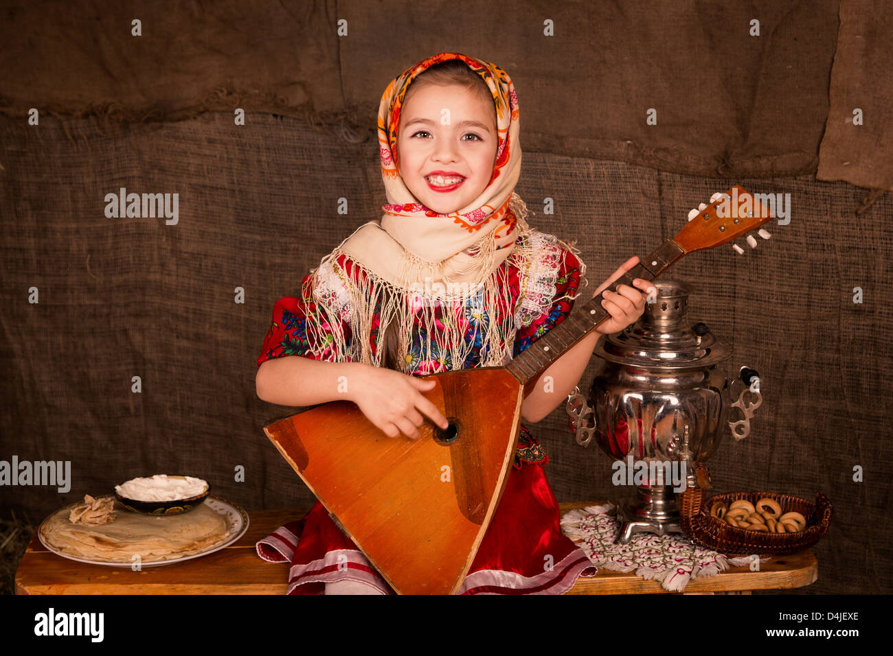 Beautiful russian girl in a shawl playing balalaika Stock Photo - Alamy