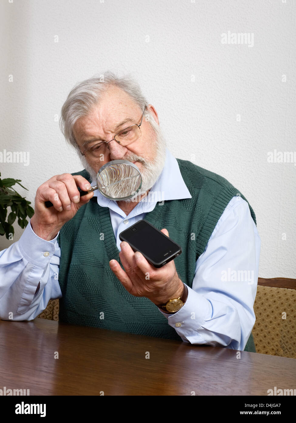 Senior man watching his new smart phone under loupe Stock Photo - Alamy