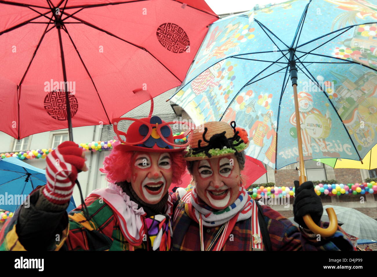 Carnival goers hold up umbrellas during the Shrove Monday parade in ...