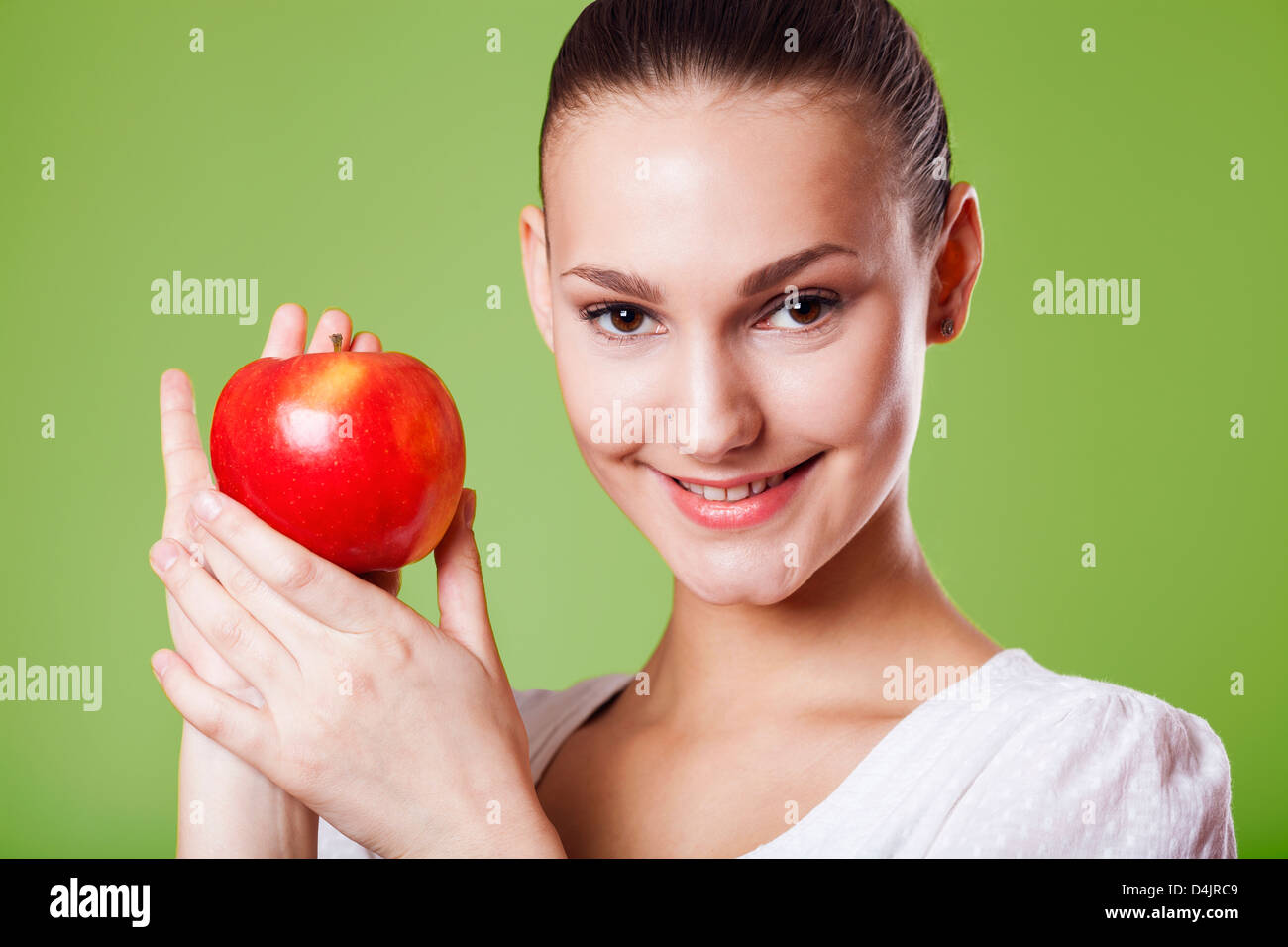 Head shot of woman holding apple Stock Photo - Alamy