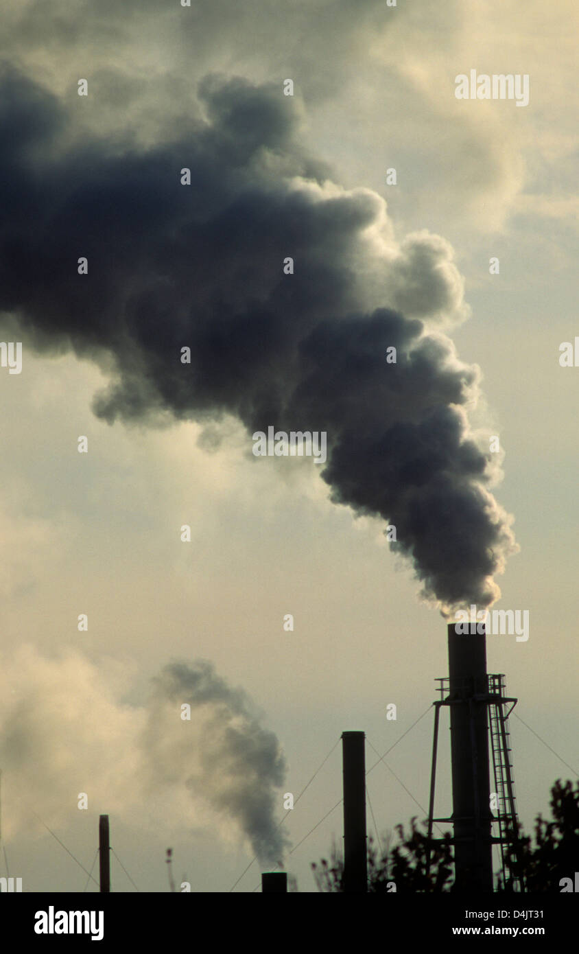 Industrial smokestacks release thick plumes of smoke into the ...